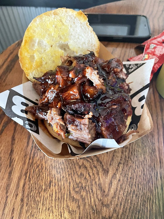 Behold the brisket sandwich in its natural habitat&mdash;glistening with sauce, bark intact, ready to transport you to a higher plane of existence.