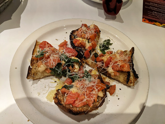 Behold the bruschetta that launched a thousand return visits – perfectly charred bread supporting a mountain of tomatoes that actually taste like tomatoes.