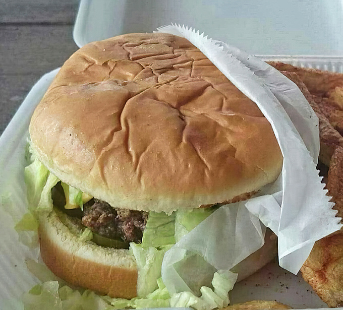 That golden bun cradles a patty thick enough to require architectural engineering but tastes like pure heaven.