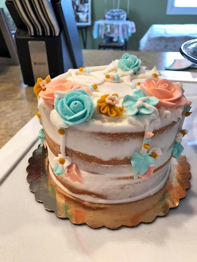 Not just donuts! This naked cake adorned with delicate pastel flowers proves Marge's artistry extends well beyond the humble donut hole.