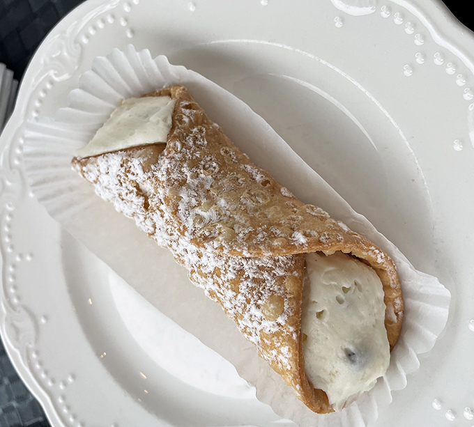 The star of the show: a perfectly crisp cannoli shell filled with sweet ricotta cream and dusted with powdered sugar&mdash;proof that the simplest pleasures are often the most profound.