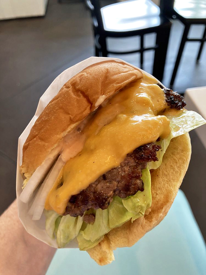 Behold the star of the show! This cheeseburger's melty American cheese cascades over a perfectly seared patty like a yellow waterfall of joy.