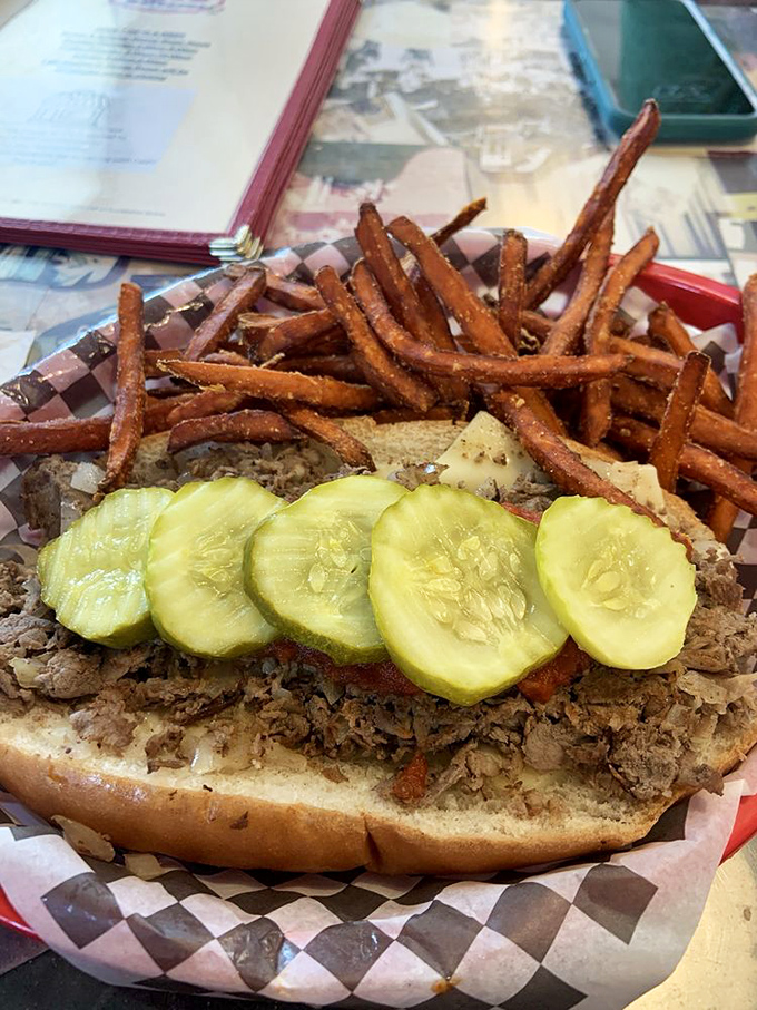 This isn't just a sandwich; it's a barbecue masterpiece with pickle crowns. Those sweet potato fries aren't sides—they're supporting actors deserving their own Oscar.
