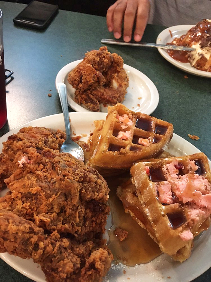 Behold the star attraction: golden-brown fried chicken perched atop Belgian waffles with strawberry butter. This isn't breakfast&mdash;it's an edible hug.
