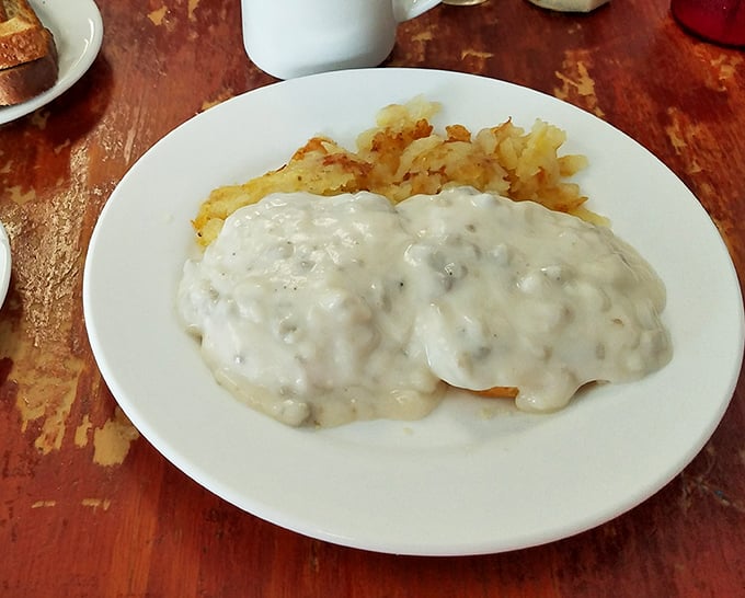 Golden chicken fried steak arrives like comfort food royalty, crowned with creamy white gravy.