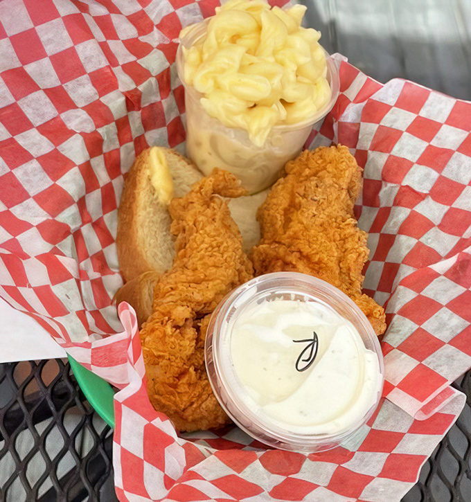 Golden-brown chicken tenders nestled in checkered paper with mac and cheese that's unapologetically creamy&mdash;this is what comfort food dreams are made of.