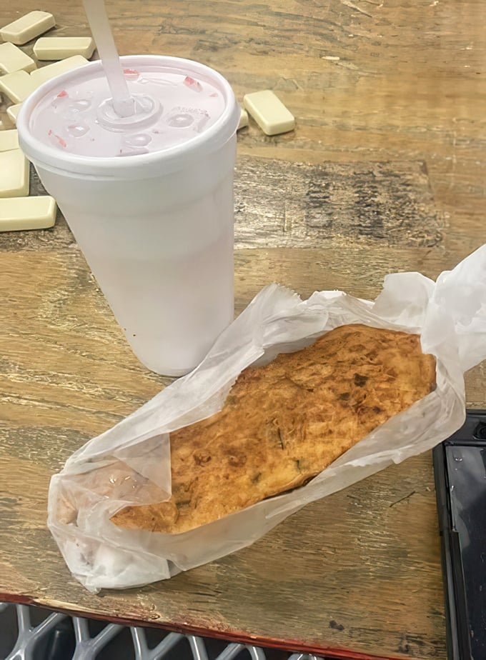 The perfect Miami power couple: crispy conch fritter meets ice-cold refreshment in styrofoam-wrapped harmony.