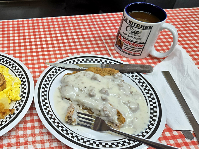 Country fried steak swimming in creamy gravy &ndash; where comfort food meets art form. The fork marks tell you someone couldn't wait!