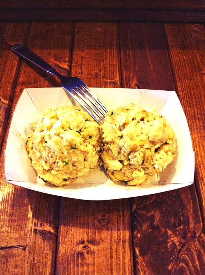 Two golden-brown monuments to crab perfection sitting pretty in their paper boat. Minimalist presentation, maximum flavor&mdash;exactly as it should be.