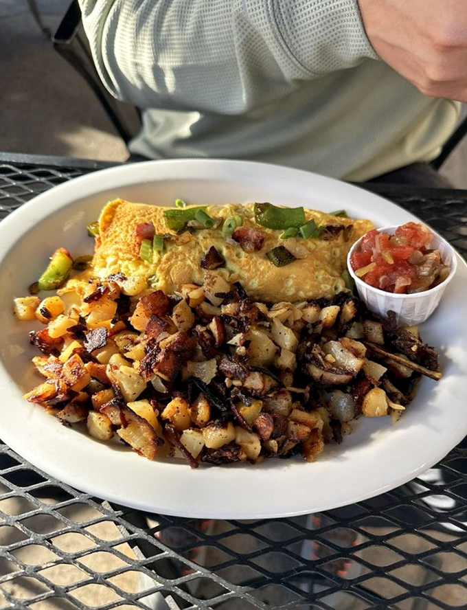 The Denver omelette arrives like a golden pillow stuffed with ham, peppers, and onions - breakfast perfection personified.