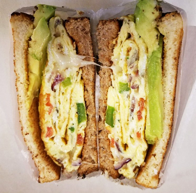 This isn't just an egg sandwich; it's breakfast architecture with perfectly melted cheese and avocado that makes Monday mornings bearable again.