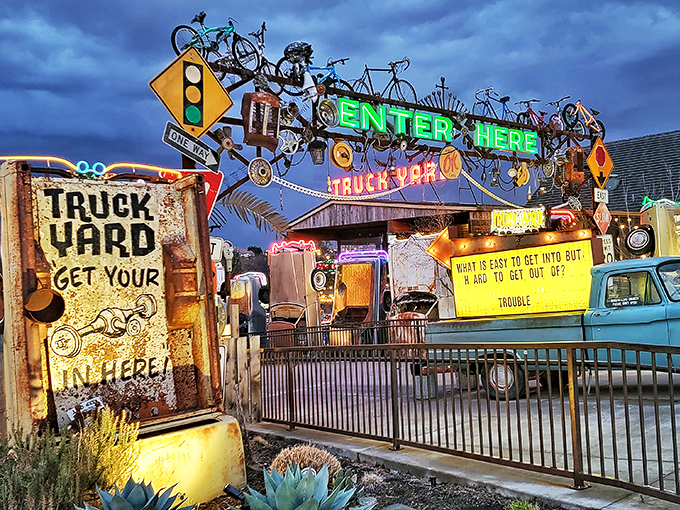 Enter Here beckons the neon sign at Truck Yard, where vintage vehicles and quirky decor create an only-in-Texas atmosphere.