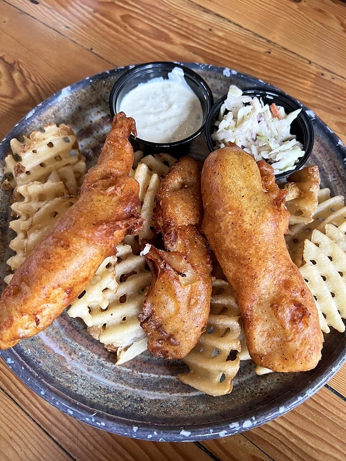 Golden-battered fish perched atop waffle fries&mdash;this isn't just fish and chips, it's edible sunshine. The crispy exterior gives way to flaky perfection that would make Neptune himself jealous.