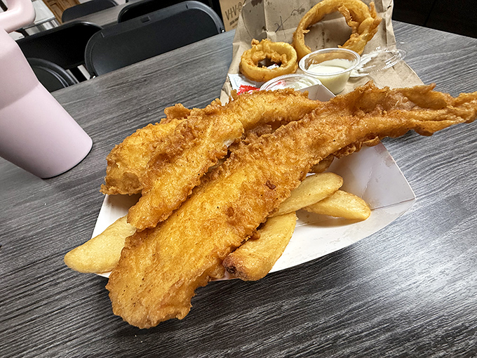 Golden-battered fish fillets perched atop thick-cut chips&mdash;this isn't just food, it's edible architecture designed by someone who understands comfort.