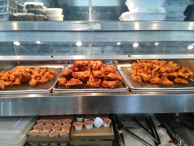 Golden-brown chicken perfection waiting behind glass like edible museum exhibits. The kind of display that makes your stomach growl loud enough to embarrass you.