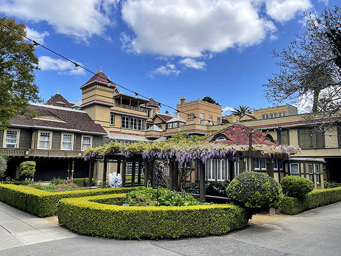 The meticulously maintained gardens provide a deceptively normal counterpoint to the architectural chaos that awaits within.