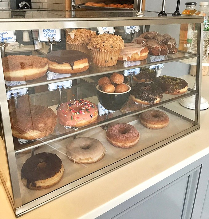 Donut heaven behind glass! Each perfectly crafted circle promises a different adventure – from classic glazed to wild flavor experiments.