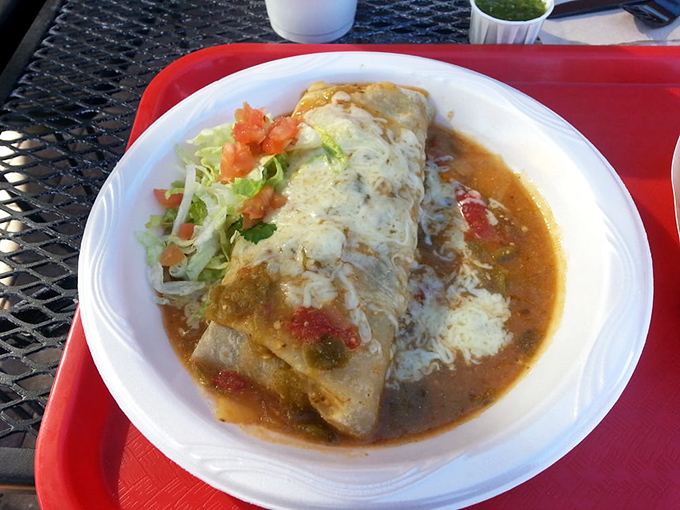 Green chili burrito swimming in sauce - because sometimes life needs extra comfort on a plate.