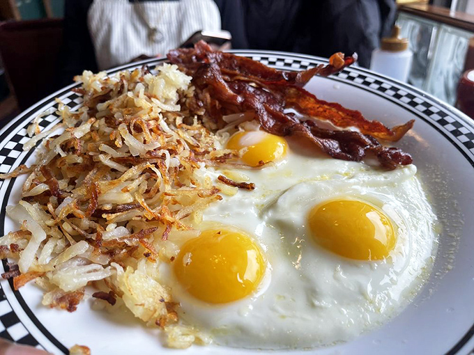 Breakfast nirvana on a plate &ndash; three sunny-side-up eggs with hash browns crisped to golden perfection and bacon that shatters like glass.