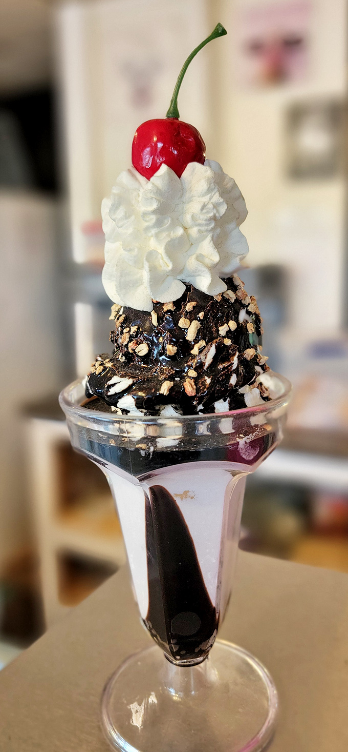 This hot fudge sundae isn't just dessert&mdash;it's architecture. The cherry stands like a flag planted at the summit of Whipped Cream Mountain.
