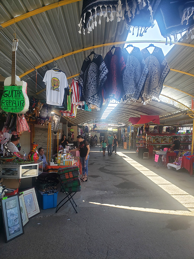 Poncho vendors create a kaleidoscope of patterns against the market's industrial backdrop. Like wearable souvenirs of the borderland, each tells its own story.