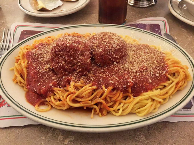 Behold the holy trinity of Italian comfort: perfectly coiled spaghetti, meatballs that defy gravity, and a marinara sea that demands to be navigated with bread.