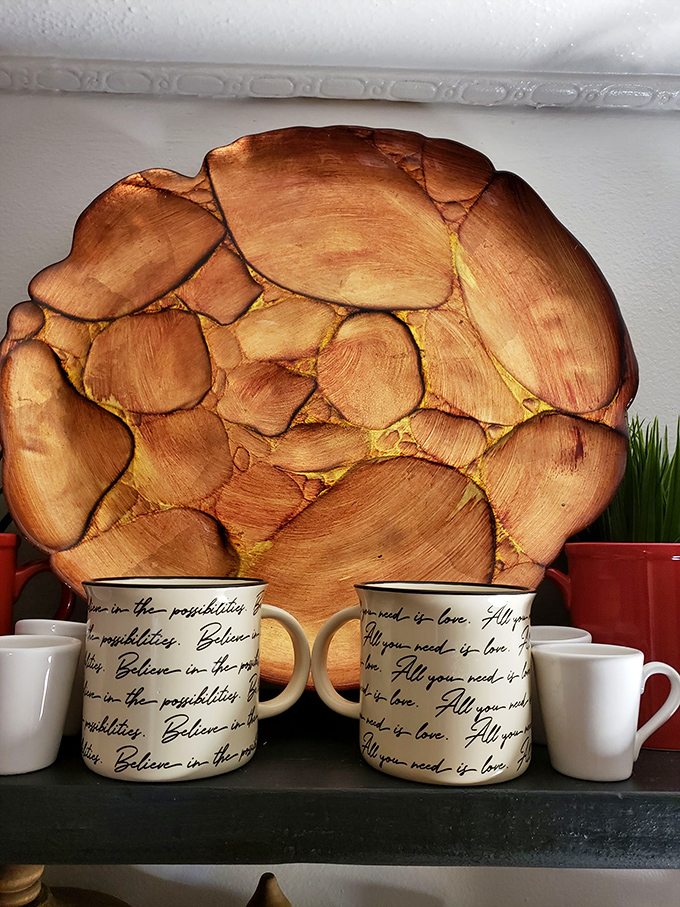 "All you need is love" mugs nestled against natural wood art. Marie Kondo would approve—these items definitely spark joy.