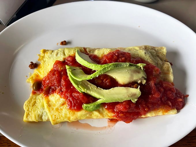 This isn't just an omelet; it's a love letter to breakfast with fresh avocado and salsa. The kind of dish worth setting an alarm for.