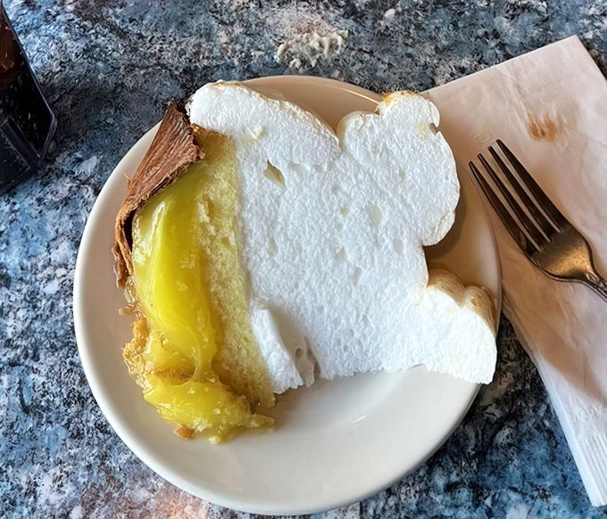 Lemon meringue pie that defies gravity with clouds of pillowy meringue floating above sunshine-yellow filling&mdash;a slice of heaven on a plain white plate.