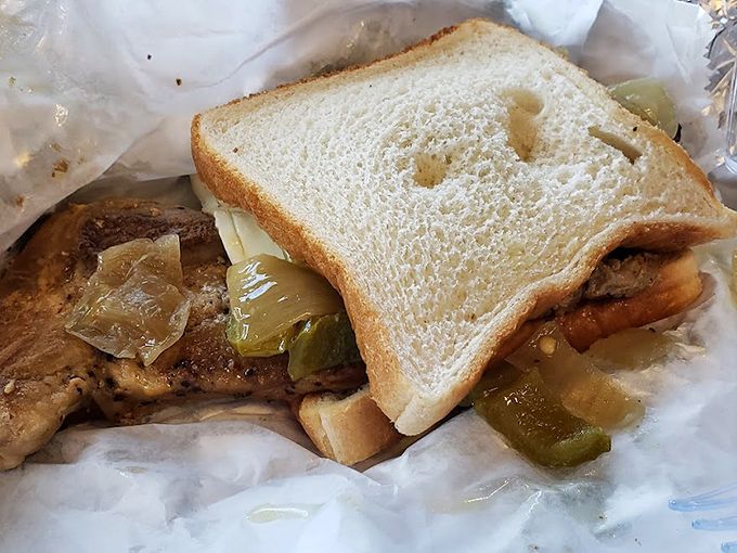 This isn't just a sandwich; it's a pork chop revelation with pickles that somehow transforms white bread into the perfect delivery system.