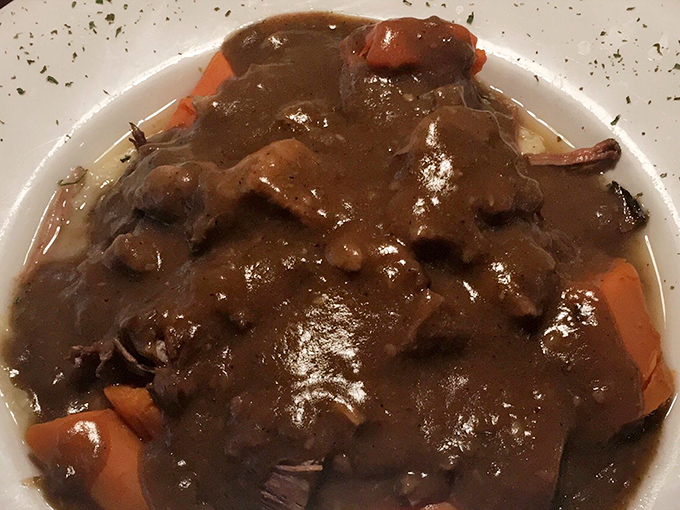 Behold the star attraction: pot roast swimming in gravy so rich it could buy a yacht. Fork-tender meat that surrenders at first touch.