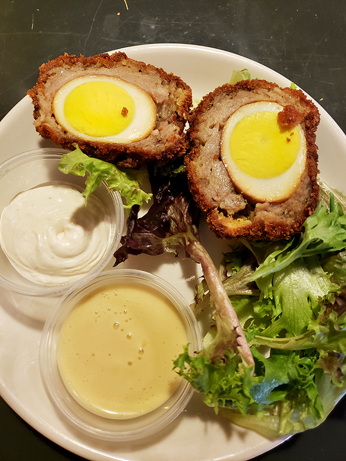 Behold the legendary Scotch egg in its natural habitat! Crispy exterior, perfectly cooked egg, and that magical layer of meat that'll haunt your dreams.