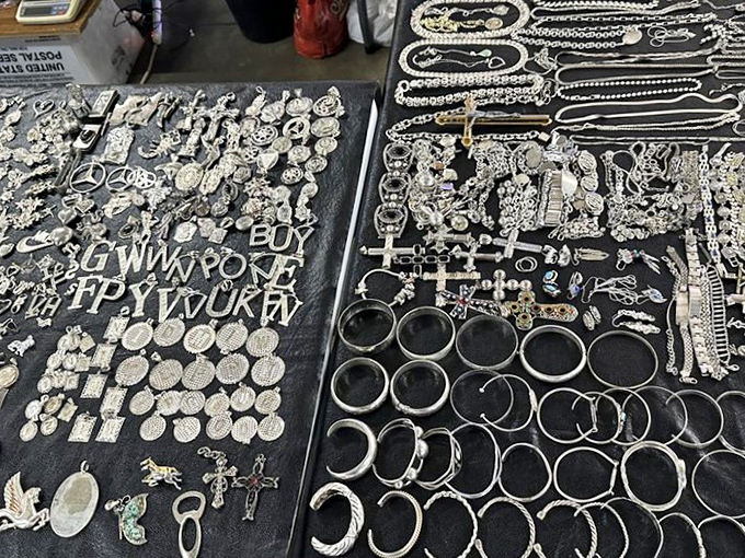Silver treasures glimmer under fluorescent lights, a pirate's bounty of pendants, rings, and charms waiting for their forever homes.