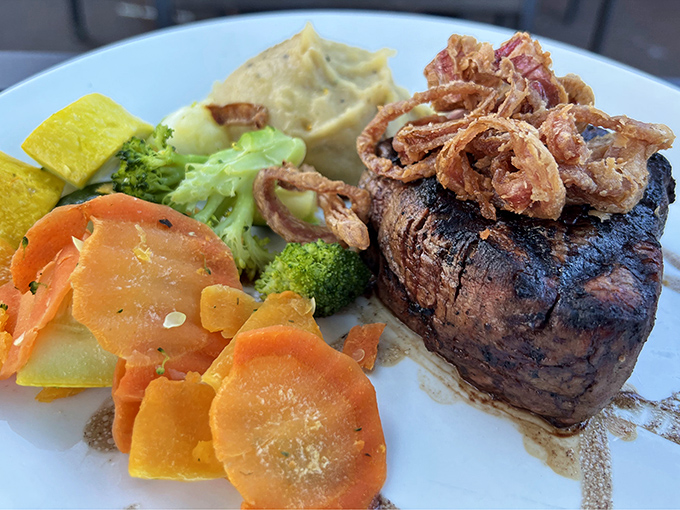Behold the steak that launched a thousand road trips! Perfectly charred exterior, tender interior, and those crispy onions are the crown jewels.