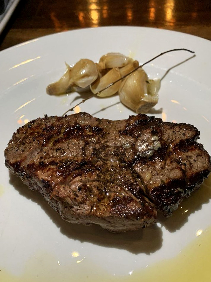 Behold: beef perfection. This perfectly seared steak with roasted garlic cloves is the kind of dish that renders conversation unnecessary for at least three blissful minutes.
