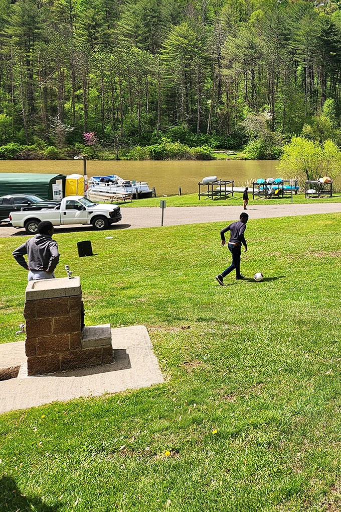 Green space meets blue water where visitors enjoy impromptu soccer matches just steps from where boats patiently wait their turn.