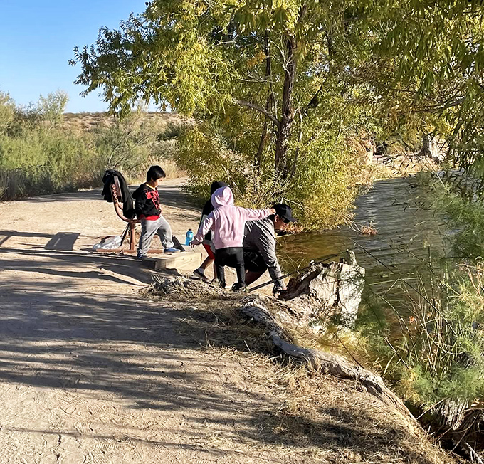 Adventure knows no age – explorers young and old discover the simple joy of skipping stones and dipping toes at the pond's edge.