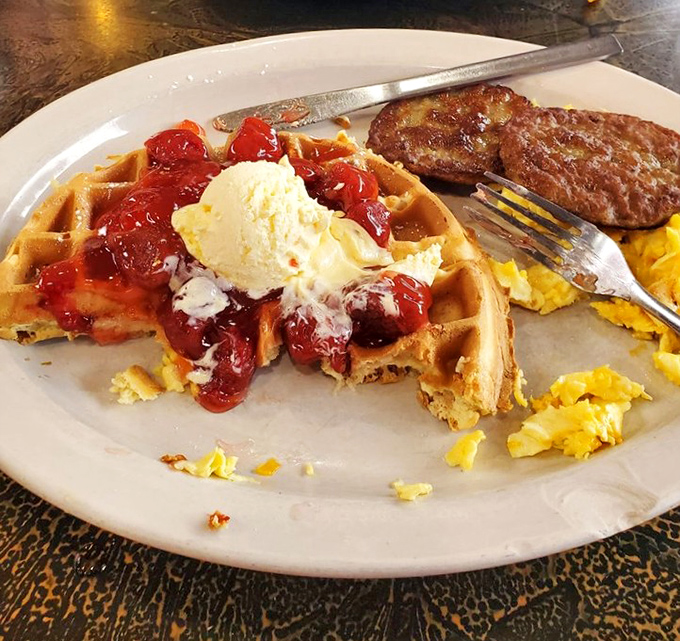 Breakfast nirvana exists, and it looks exactly like this: golden waffles crowned with strawberries and ice cream alongside perfectly scrambled eggs and sausage. Morning glory on a plate.