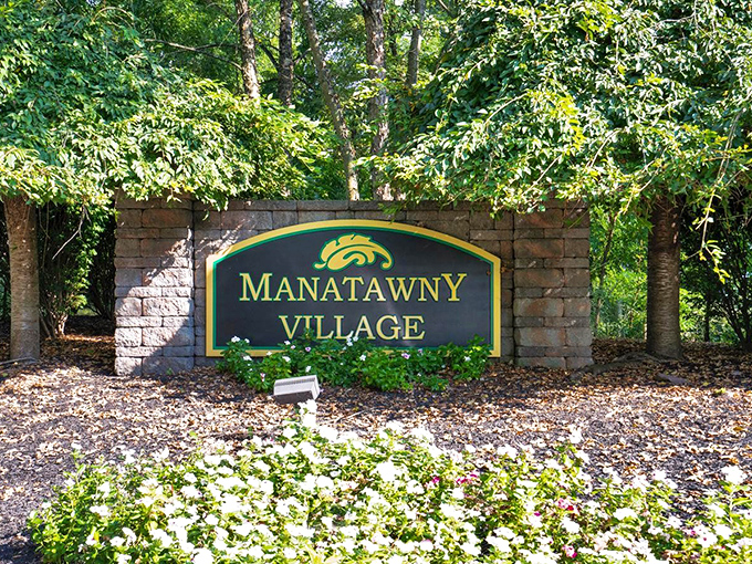 Forest-framed entrance signs promise tranquil living where nature's beauty comes standard with every home.