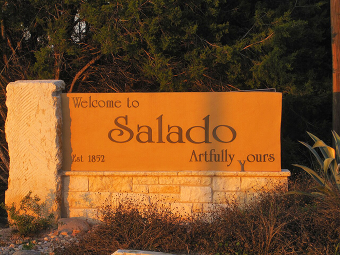 Salado's welcome sign glows in golden sunset light, inviting travelers to a town that's been "artfully yours" since 1852.