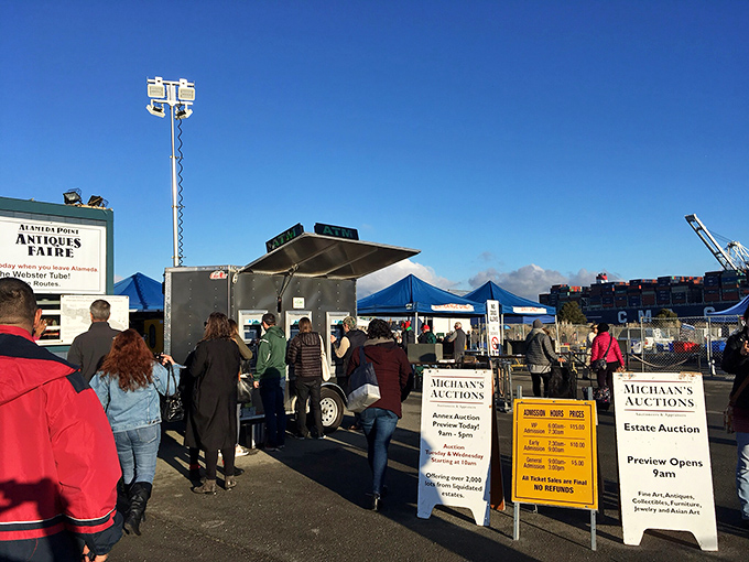 Early bird special! Dawn shoppers with rolling carts navigate Alameda's market entrance, ready to wheel away furniture treasures before most people have had their coffee.