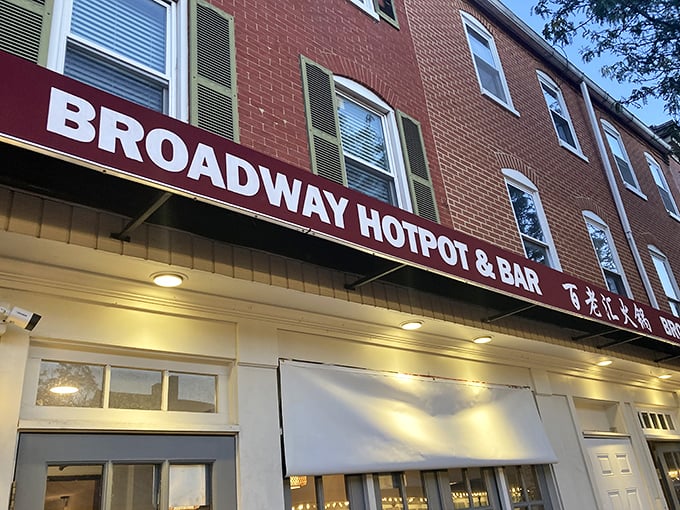 The evening glow illuminates Broadway Hotpot's inviting entrance. This unassuming storefront hides a social dining experience that's part meal, part entertainment, and all delicious. 