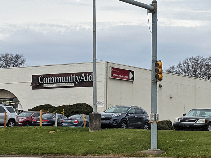 Standing tall at the intersection of bargains and benevolence, Community Aid's sign shines like a beacon for thrifty shoppers with big hearts.