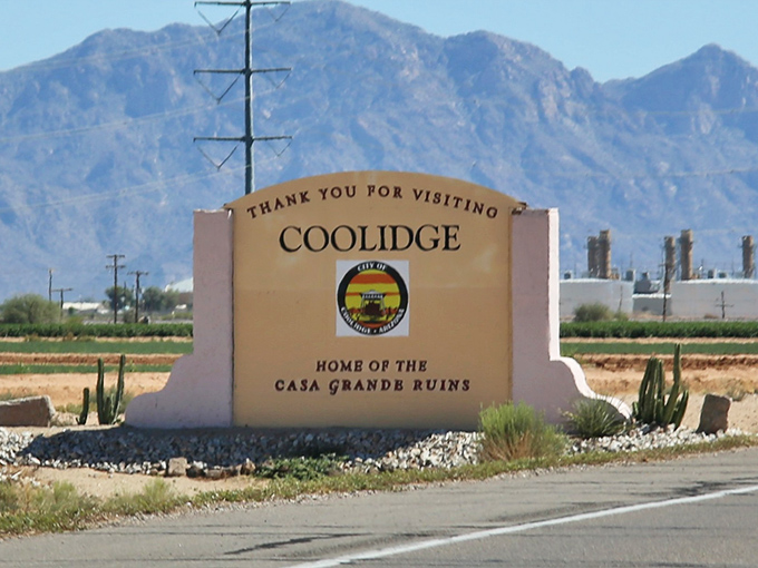 Morning light bathes Coolidge's modest buildings while distant mountains stand guard over this agricultural community.