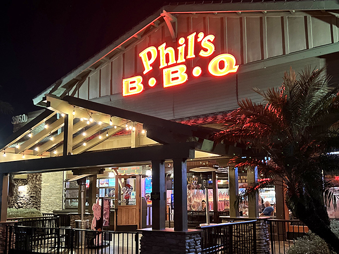 By day or night, Phil's glowing sign beckons meat lovers like a BBQ lighthouse. The palm trees say "California," but the smoke ring says "I know exactly what I'm doing."