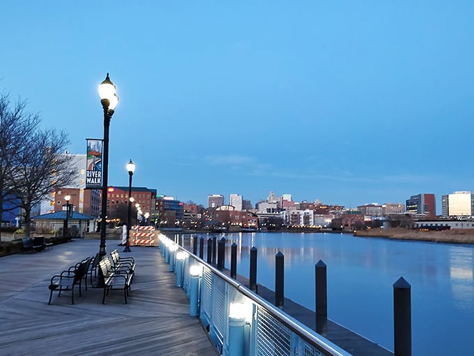 The Wilmington Riverwalk glows at dusk, inviting evening strolls along the calm water with views of the city skyline.