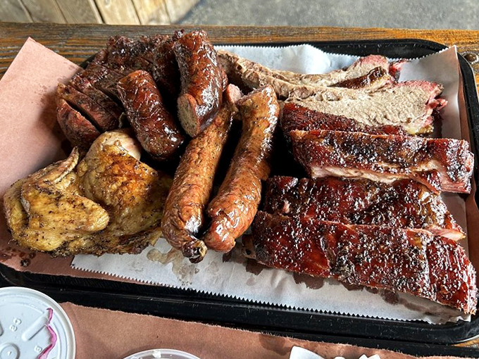 The barbecue equivalent of a royal flush – brisket, ribs, sausage, and chicken arranged on butcher paper like edible playing cards dealt by a smoke master.