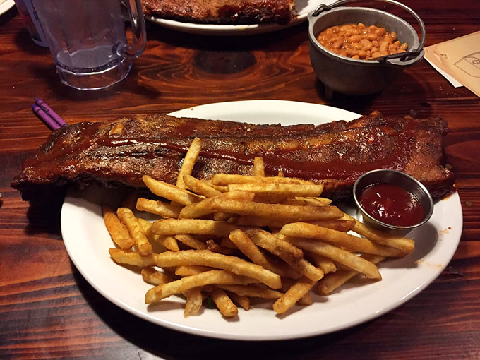 Baby back ribs that practically surrender from the bone, paired with golden fries that crunch like autumn leaves.