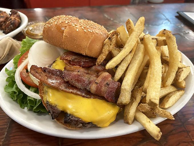This isn't just a bacon cheeseburger; it's a masterclass in comfort food architecture&mdash;crispy bacon, melted cheese, and hand-cut fries that deserve their own fan club.