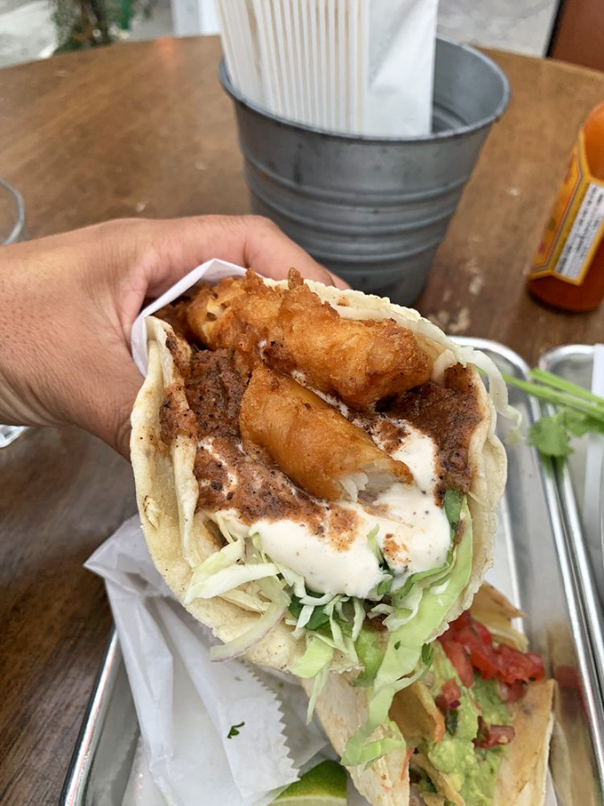 The Baja fish taco arrives like a crispy, creamy revelation—the perfect marriage of delicate fish and zesty toppings in tortilla formal wear.